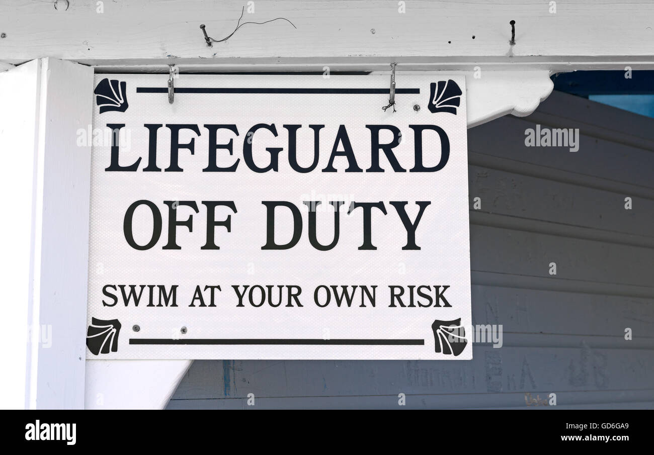 A lifeguard off duty warning sign hung at the entrance of a building ...