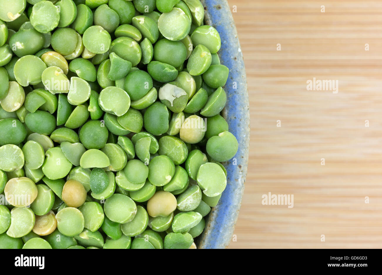 Top close view of organic green split peas filling an old stoneware ...