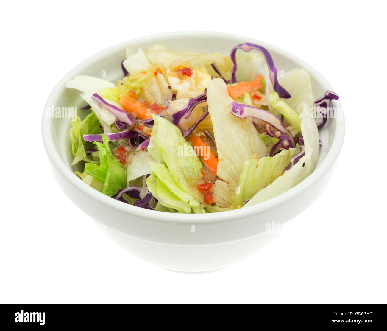 Side view of a bowl filled with sliced carrots, shredded cabbage and ...