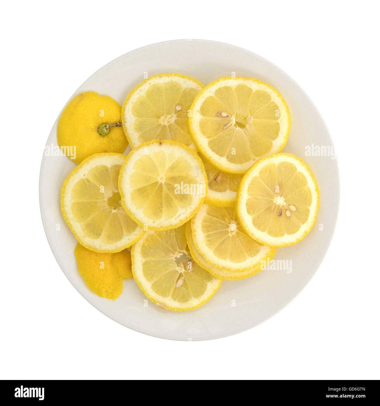 Top view of a slices of fresh lemon on an off white plate isolated on a ...