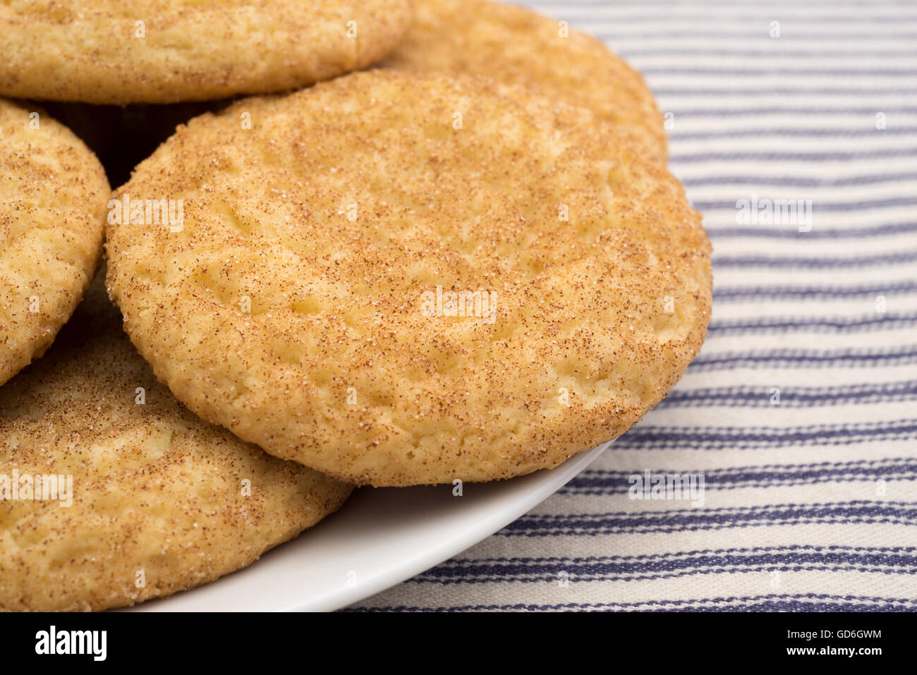 Close side view of freshly baked snickerdoodle cookies on an off white ...