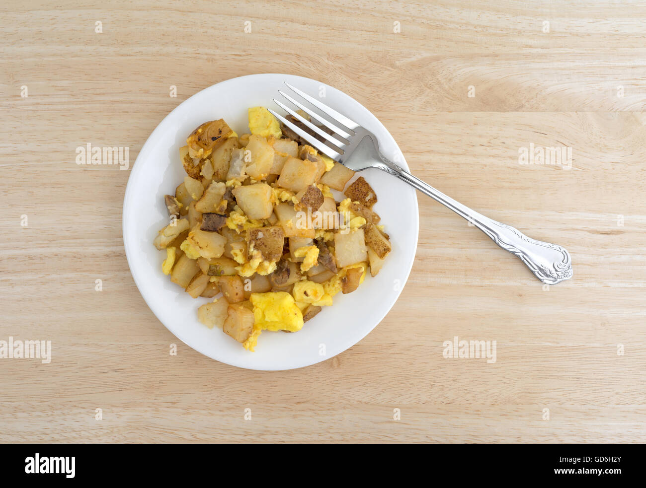 Top view of a breakfast meal on a plate with eggs, potatoes, cheese and ...