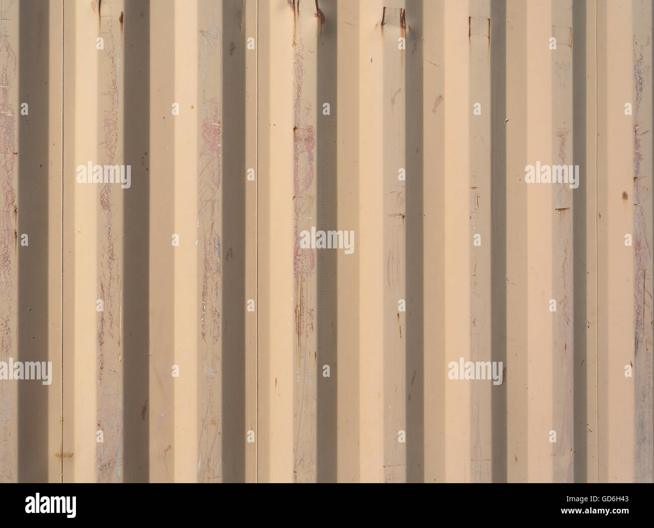 Side of a heavy gauge metal shipping container with scuffs and dents ...