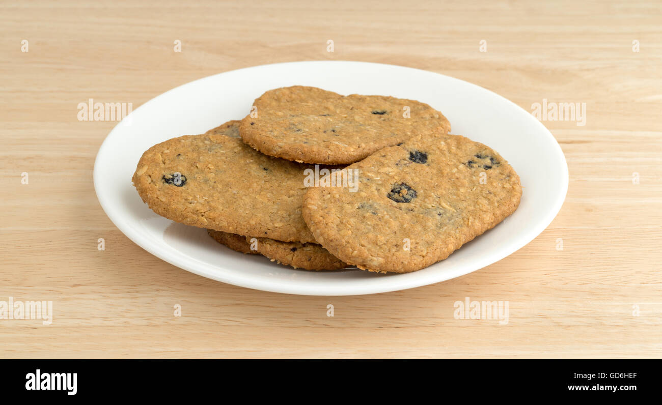 Side view of blueberry wafer cookies on a white plate atop a wood table ...