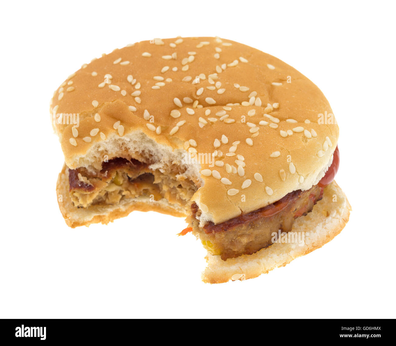 A bitten veggie burger on a bun with ketchup isolated on a white ...