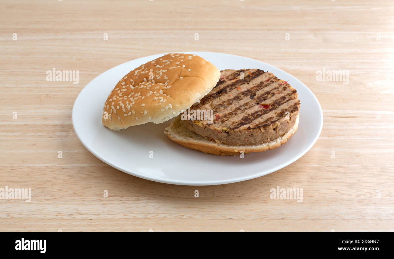 Side view of a veggie burger in a bun with no condiments on a plate ...