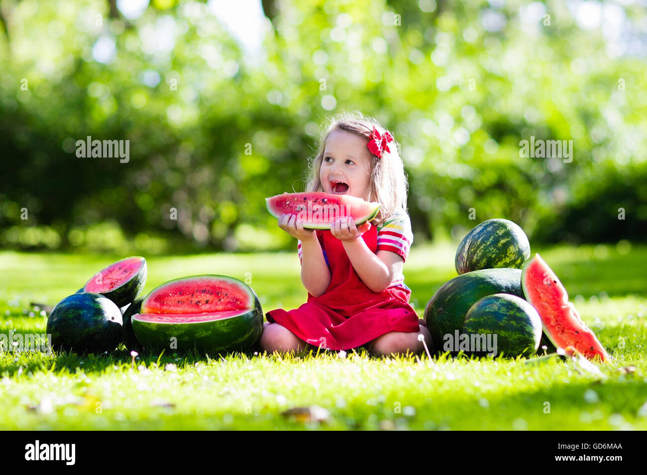 Child eating watermelon in the garden. Kids eat fruit outdoors. Healthy ...