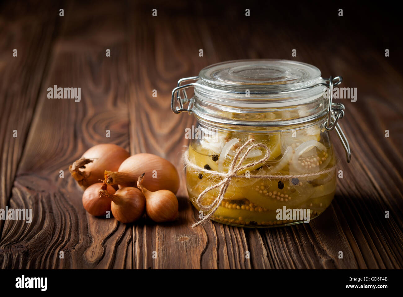 Homemade DIY natural marinated green tomatoes in a jar on wooden table ...