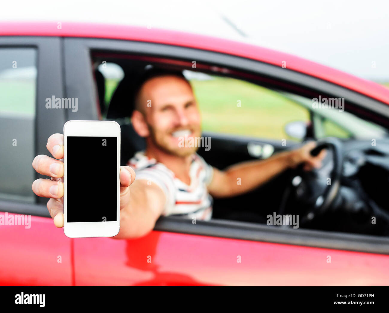 Man in car showing smart phone display smiling happy. Focus on mobile ...