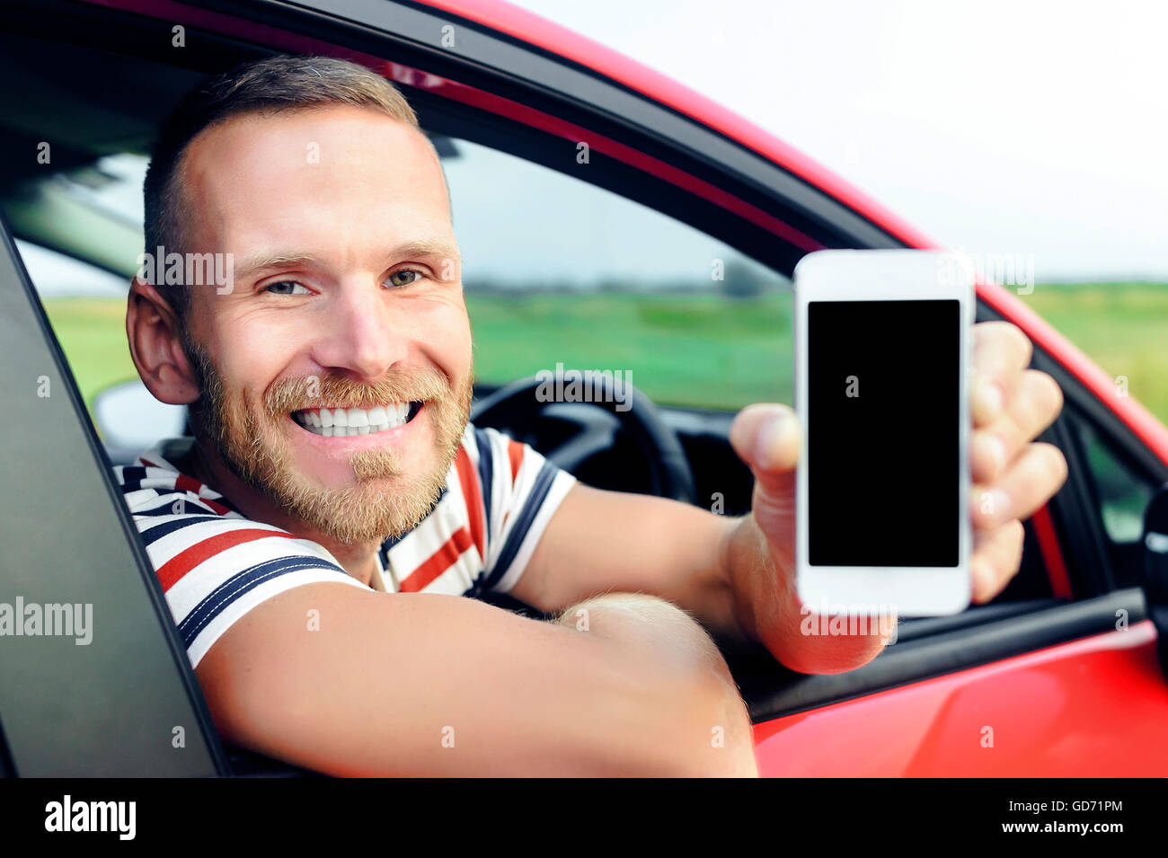Man in car showing smart phone display smiling happy. Focus on model ...