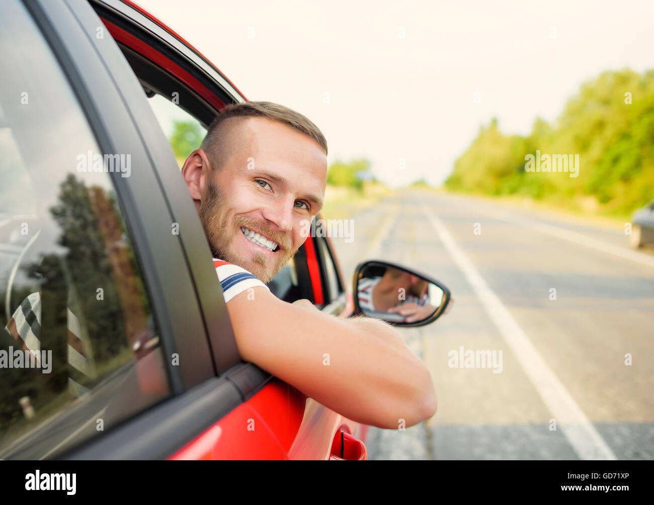 Driver. Back view. Happy smiling man in new red car on the road Stock ...