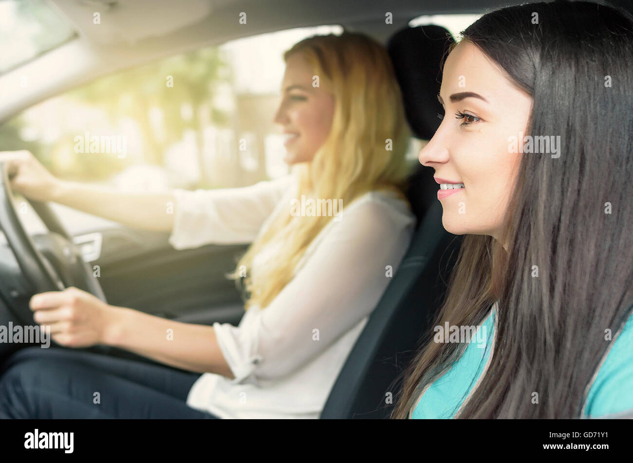 Girls in the car. Two attractive woman in car, close-up. Travel concept ...