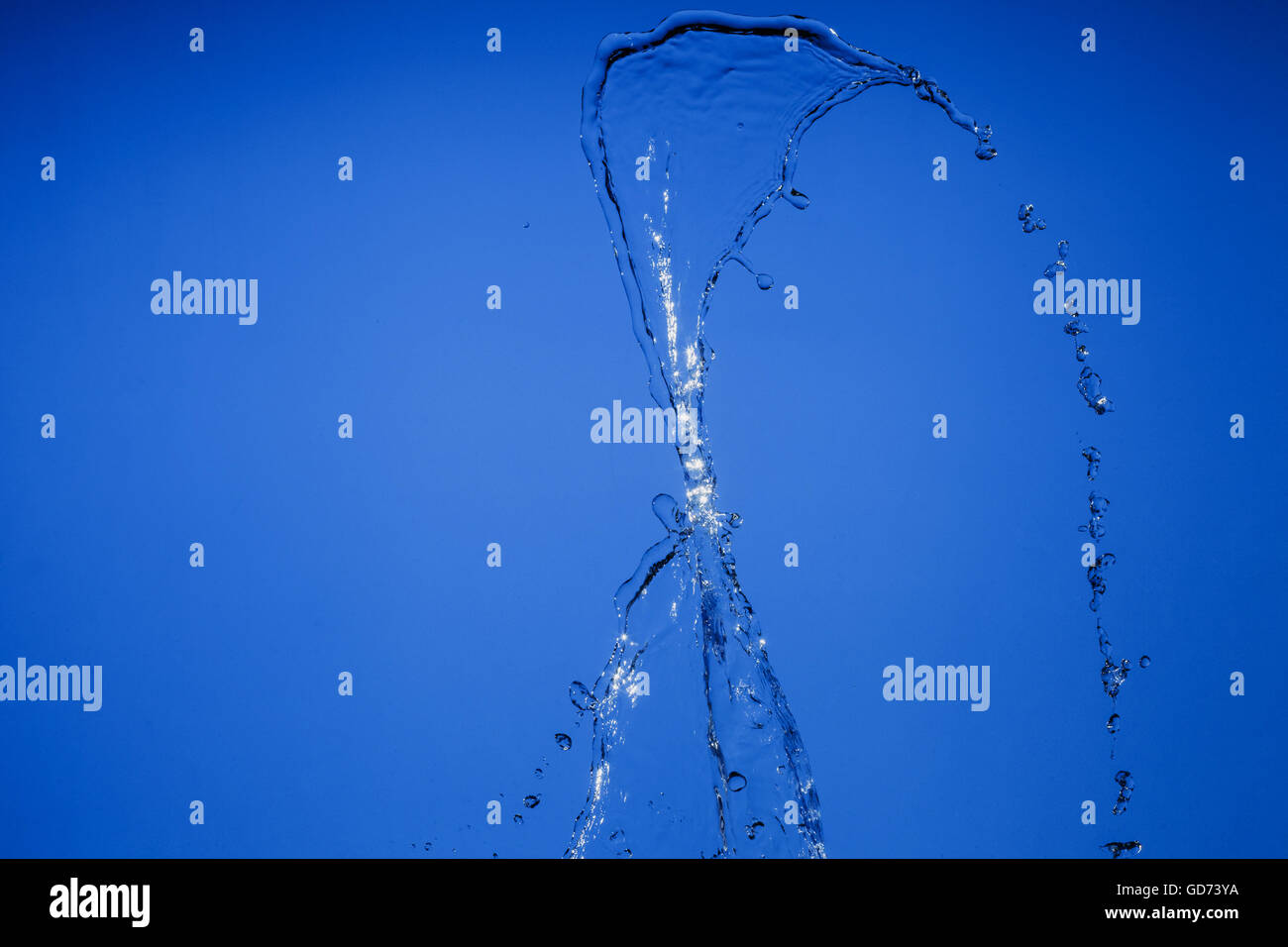Stream of water on a blue background Stock Photo - Alamy