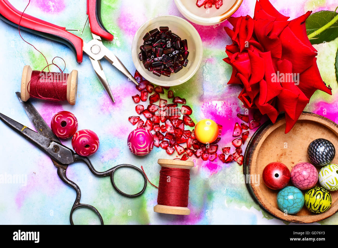 Thread and varieties of beads for making jewelry on bright colored ...