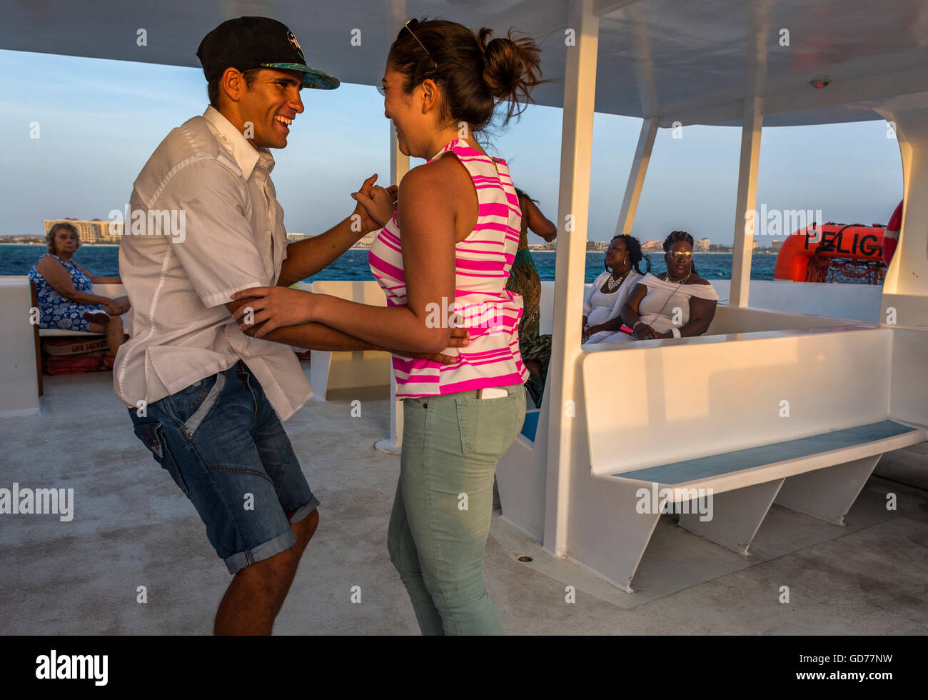 Tourists dancing on board a catamaran for a sunset cruise along the ...