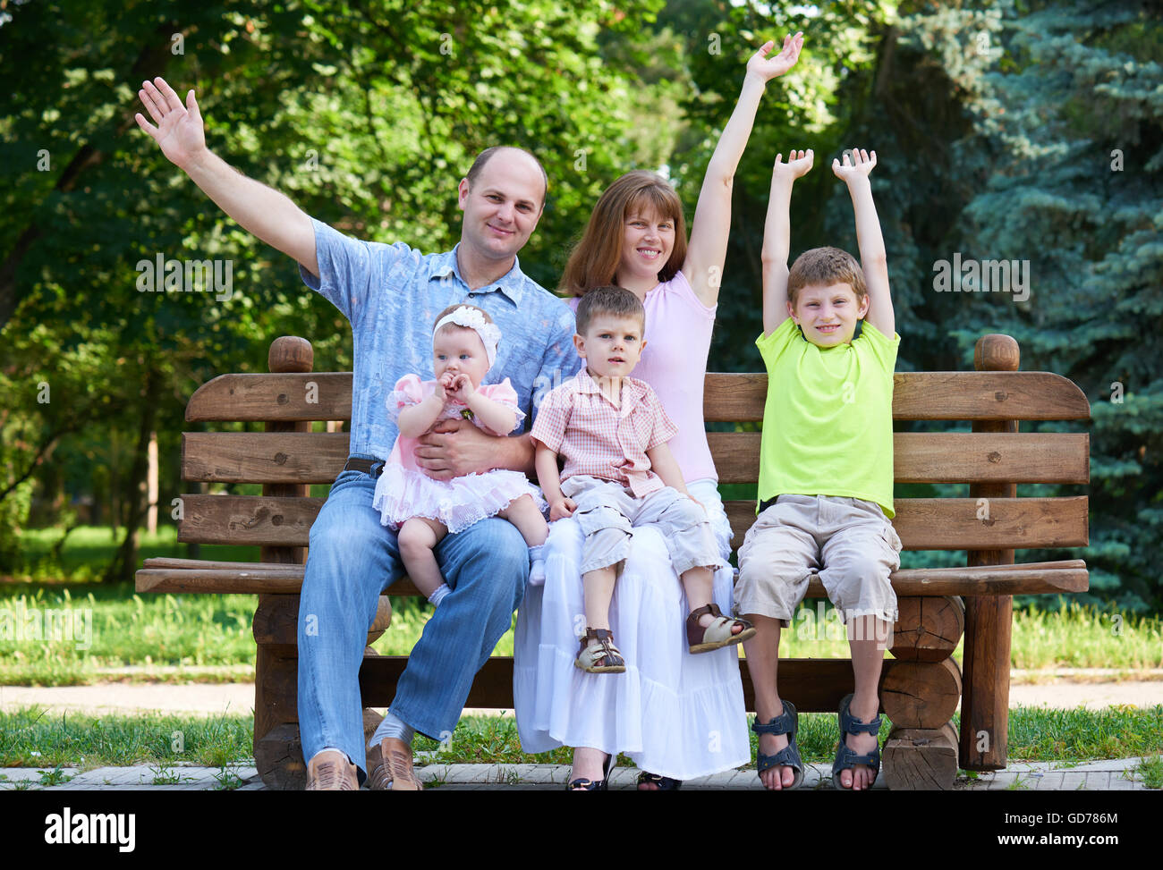 happy family portrait on outdoor, group of five people sit on wooden ...