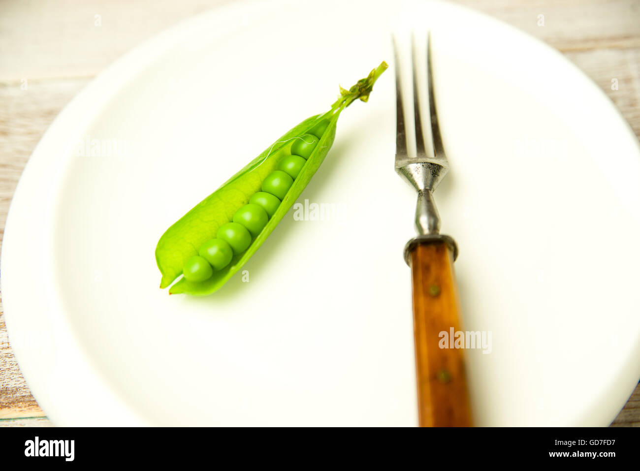 Green pea pod on the white plate Stock Photo - Alamy