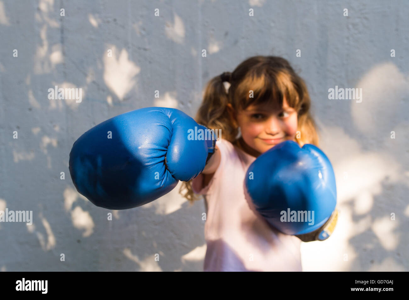 Little girl wearing blue boxing gloves Stock Photo - Alamy