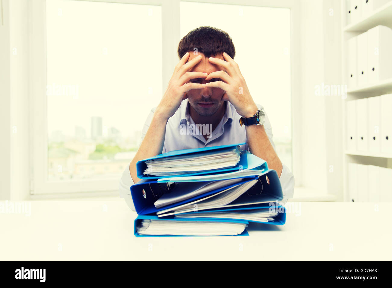 sad businessman with stack of folders at office Stock Photo - Alamy