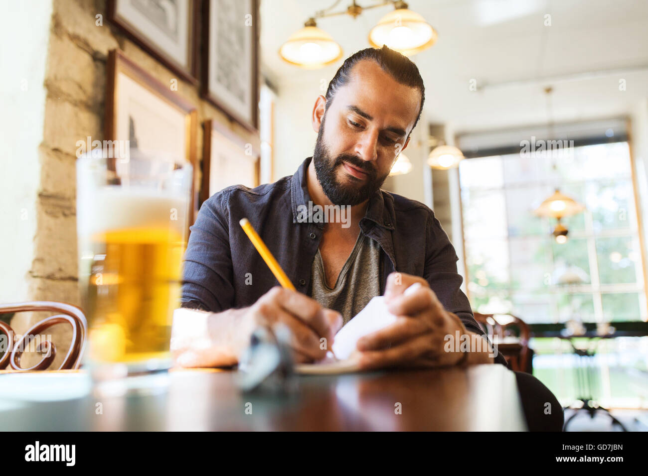man with beer writing to notebook at bar or pub Stock Photo - Alamy