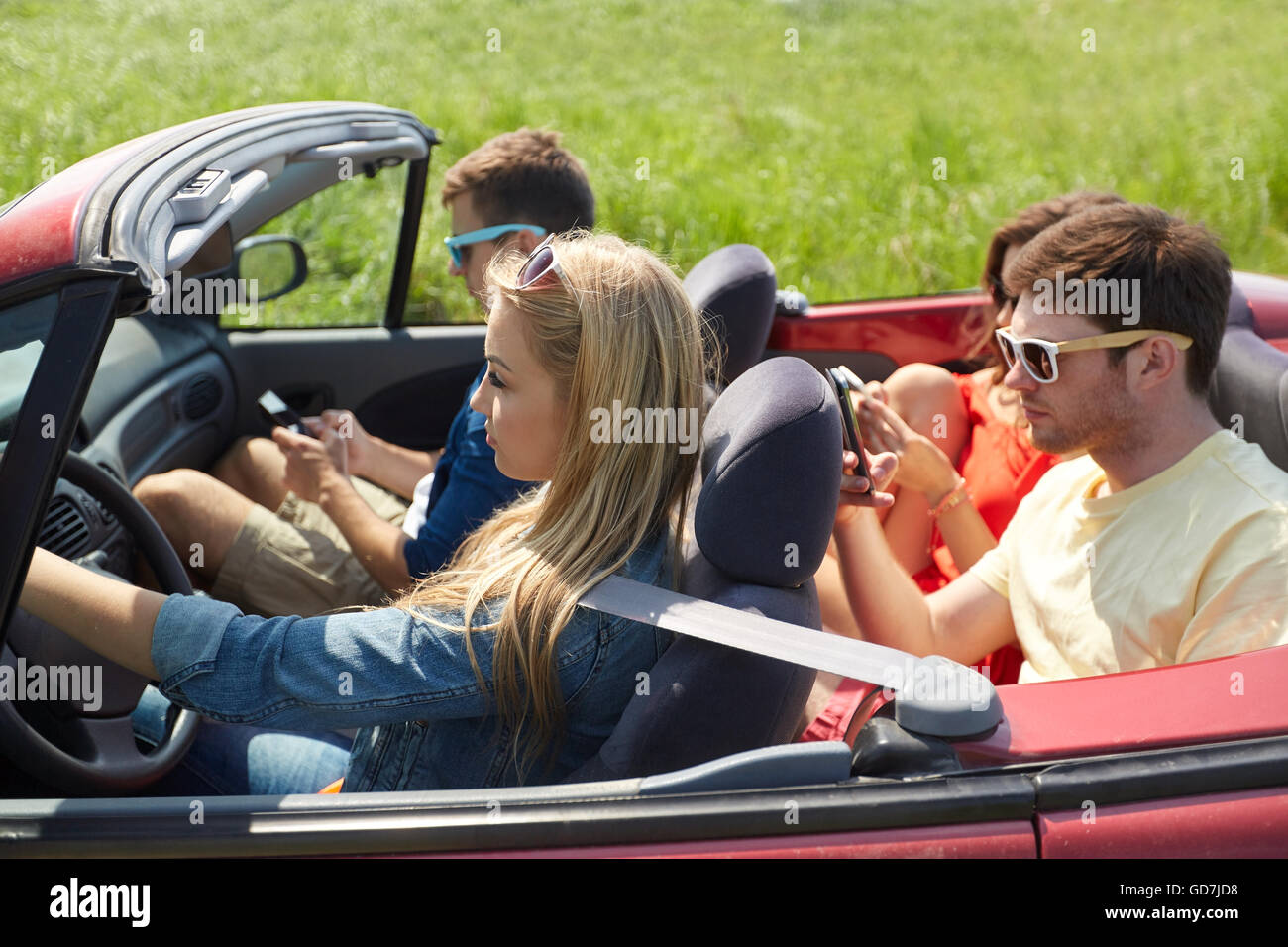 friends with smartphones driving in cabriolet car Stock Photo - Alamy