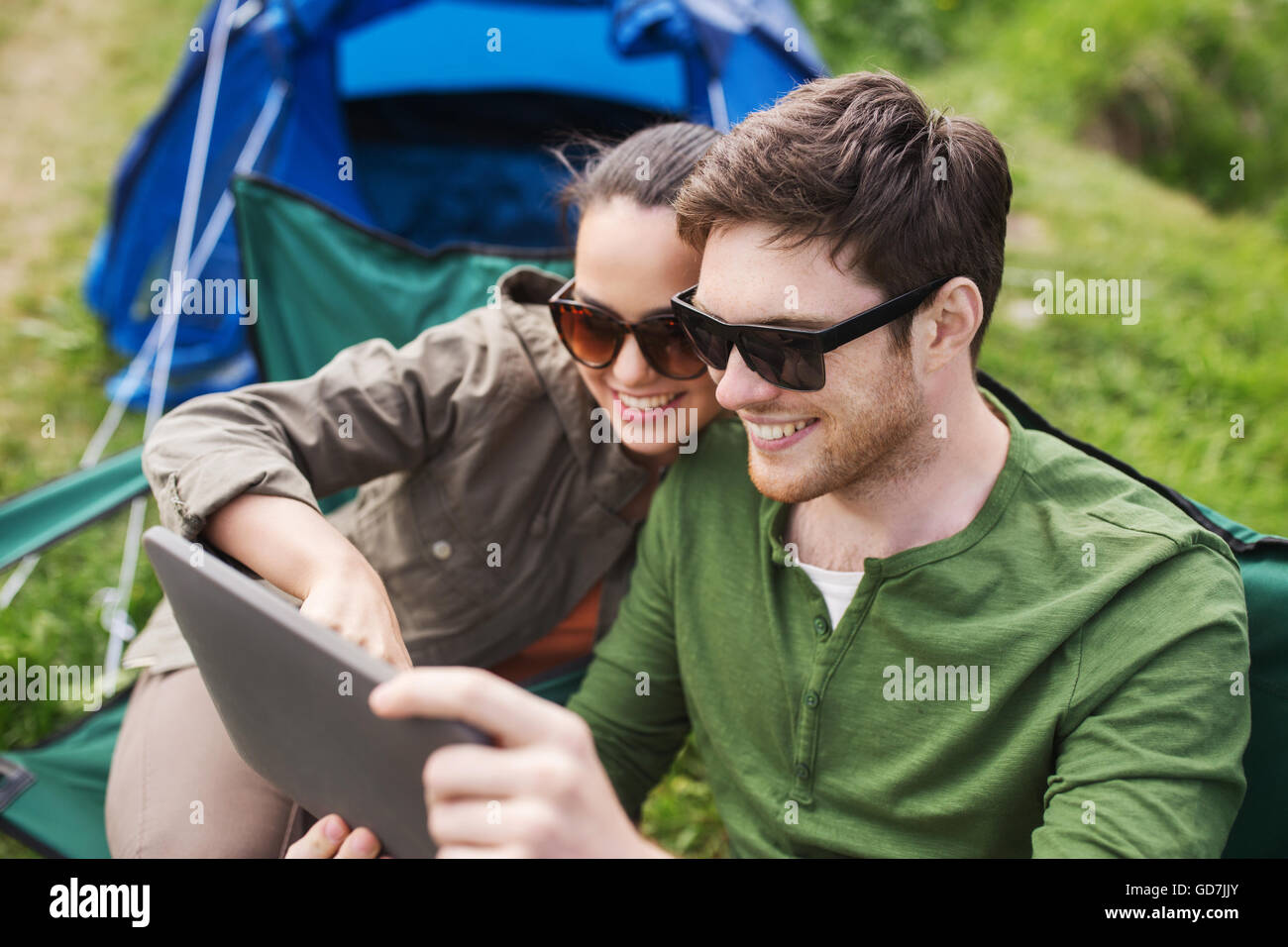 happy couple with tablet pc at camping tent Stock Photo - Alamy