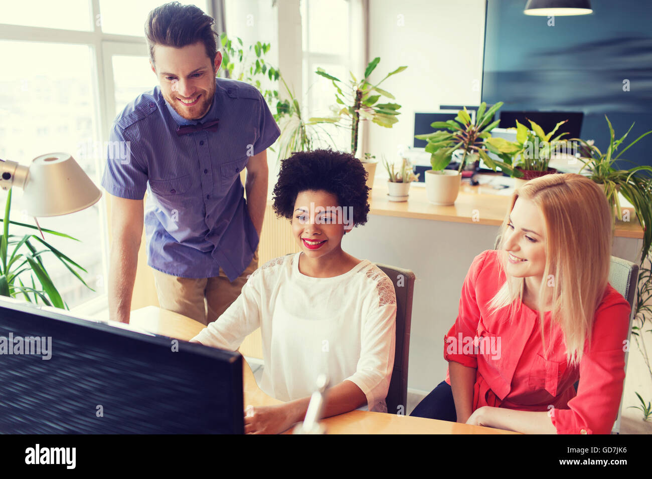 happy creative team with computer in office Stock Photo - Alamy