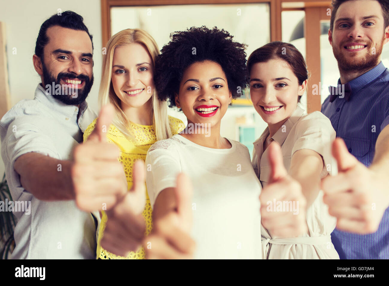 happy creative team showing thumbs up in office Stock Photo - Alamy