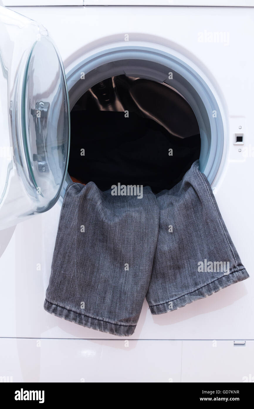 A close up of a washing machine loaded with clothes. Household ...