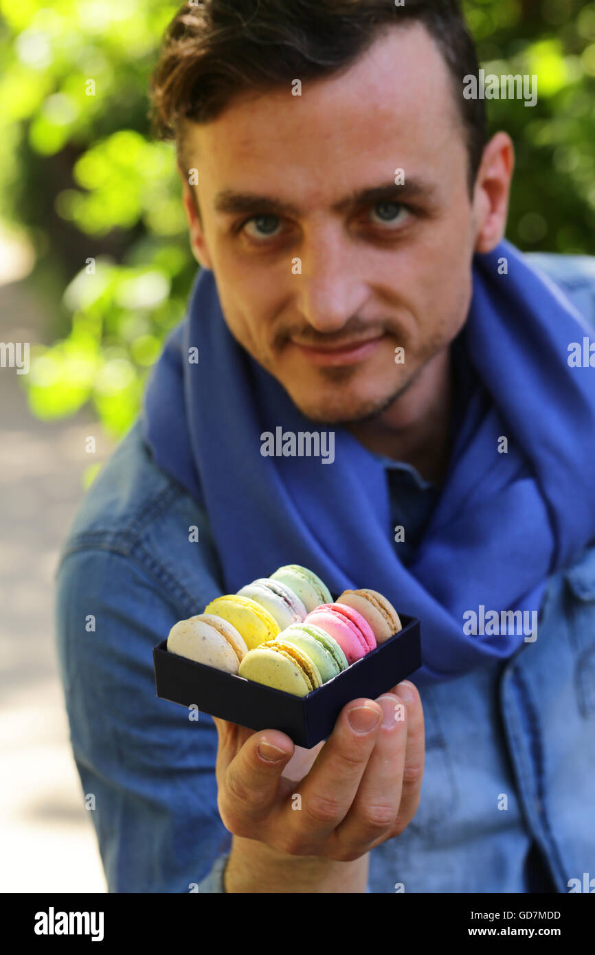 handsome young man with a box of French macaroons Stock Photo - Alamy