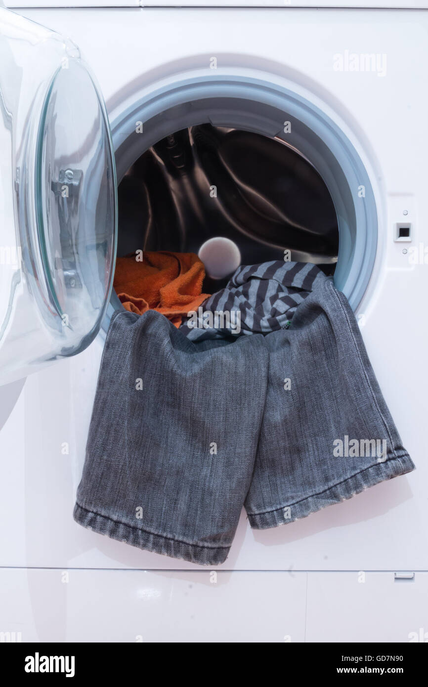 A close up of a washing machine loaded with clothes. Household ...