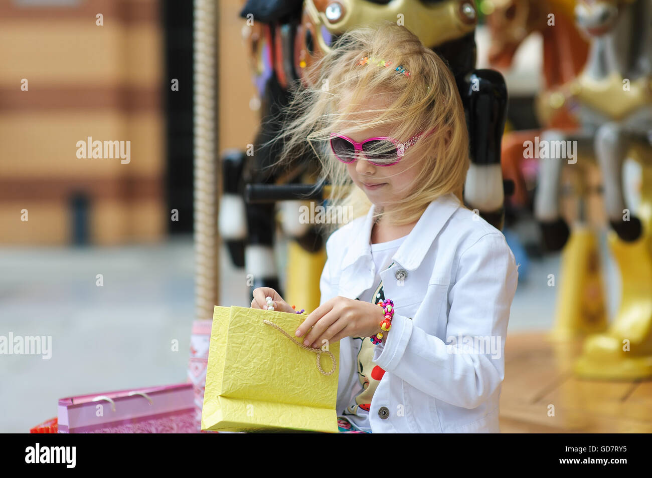 Child On Carousel with full shopping bags Stock Photo - Alamy