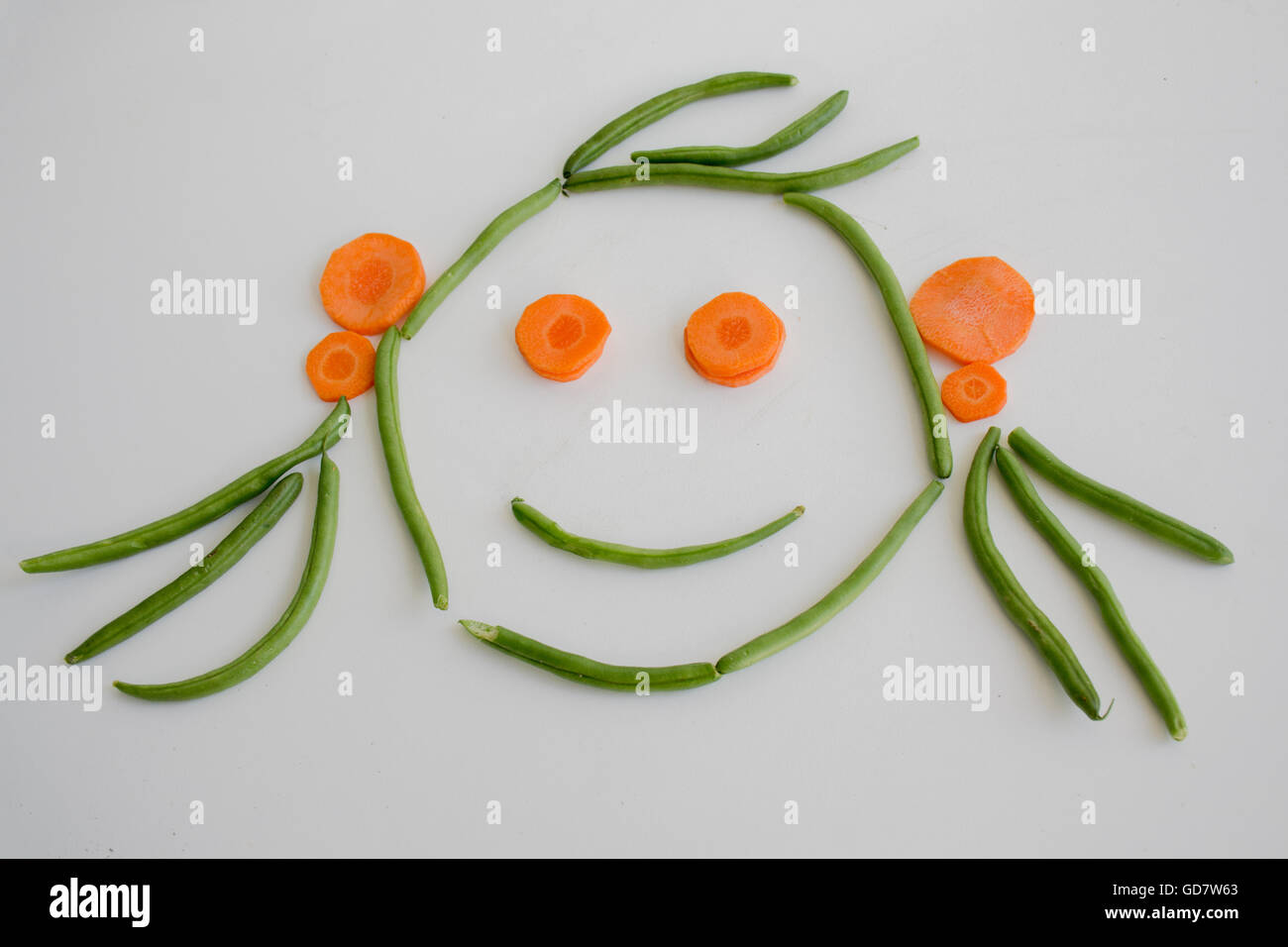 Girl face formed out of green beans and carrots Stock Photo - Alamy
