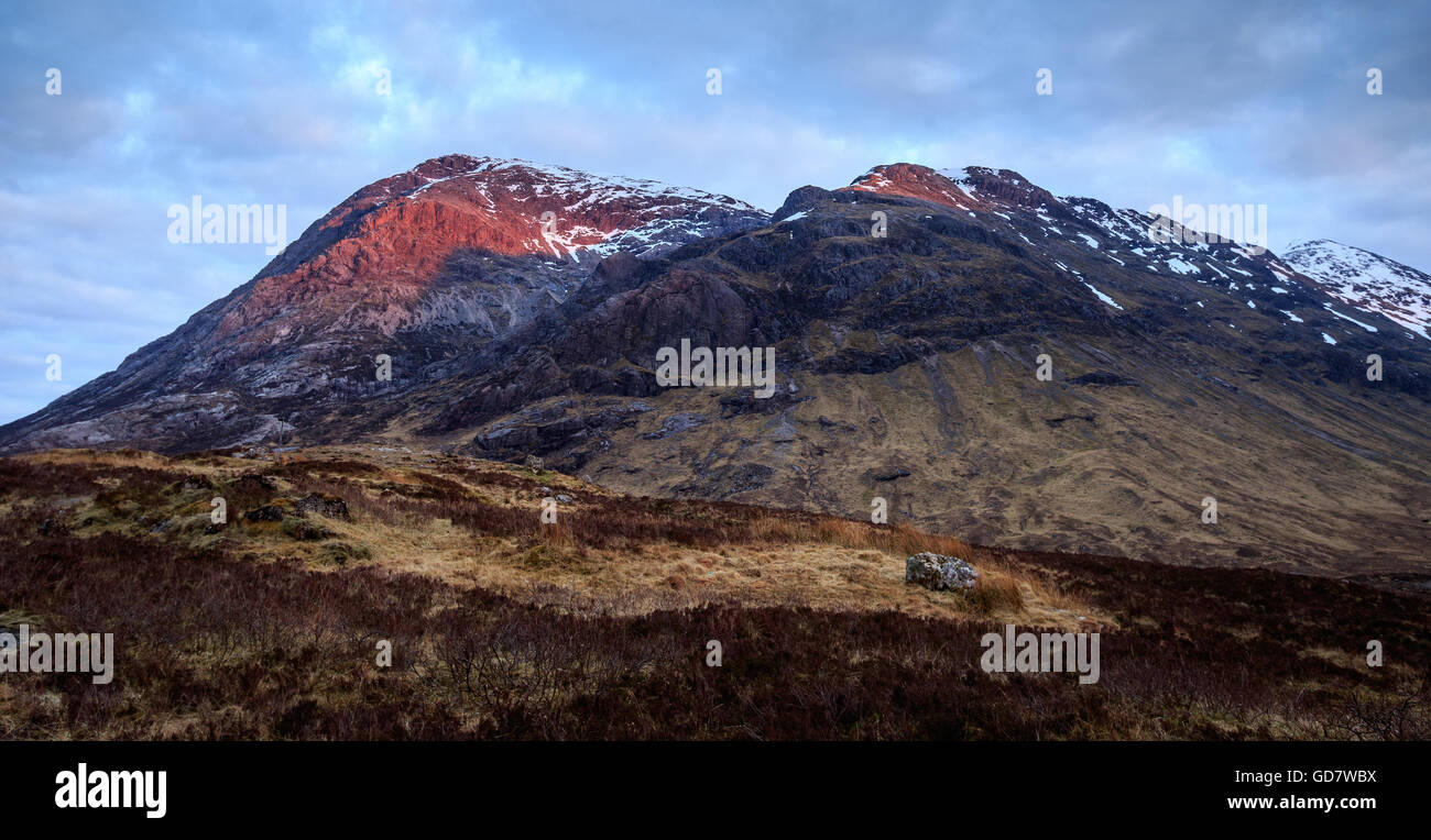 with the sun setting behind me, the peaks of this mountain, light up ...
