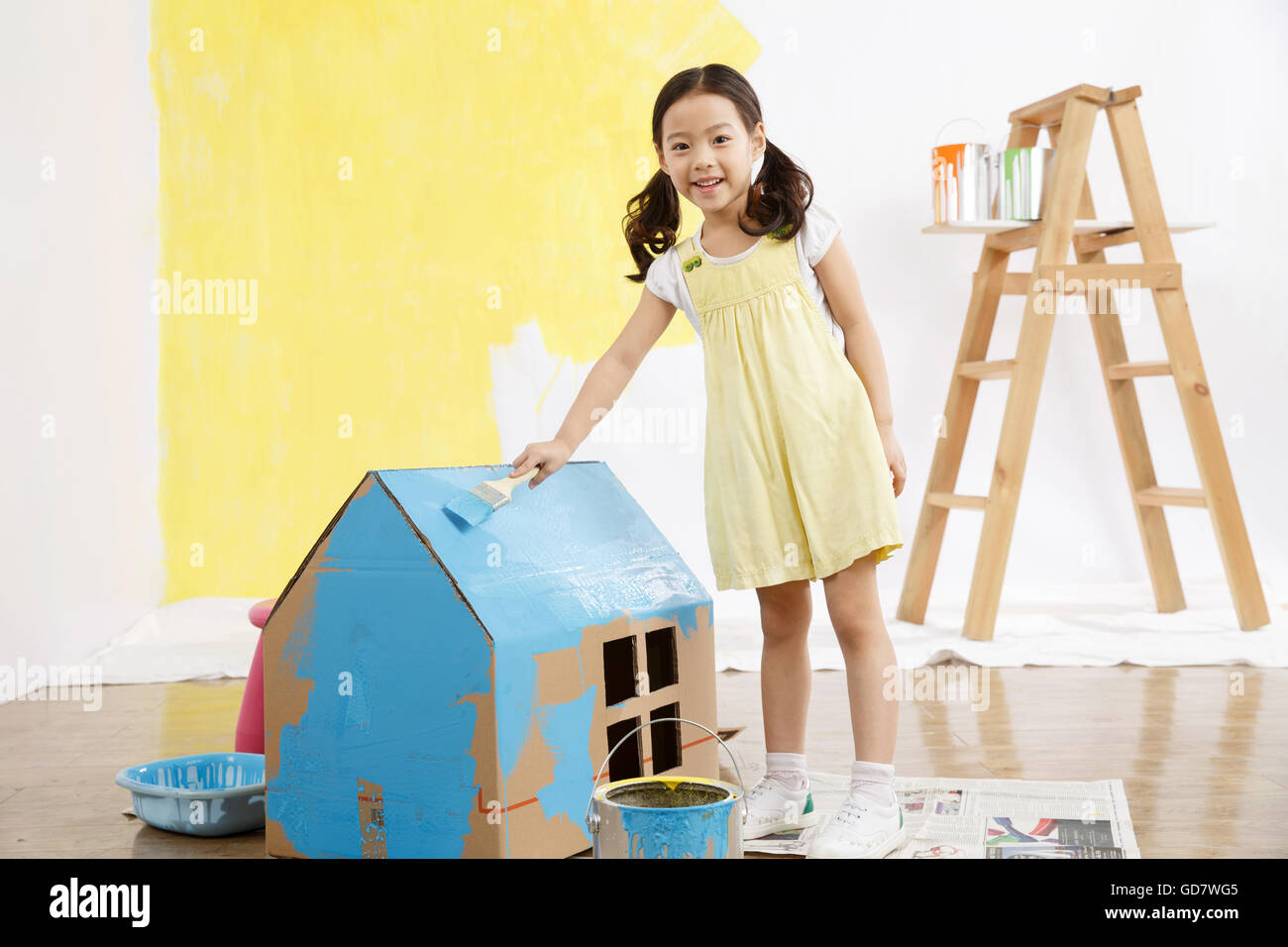 Cute little girl to paint the house model Stock Photo - Alamy