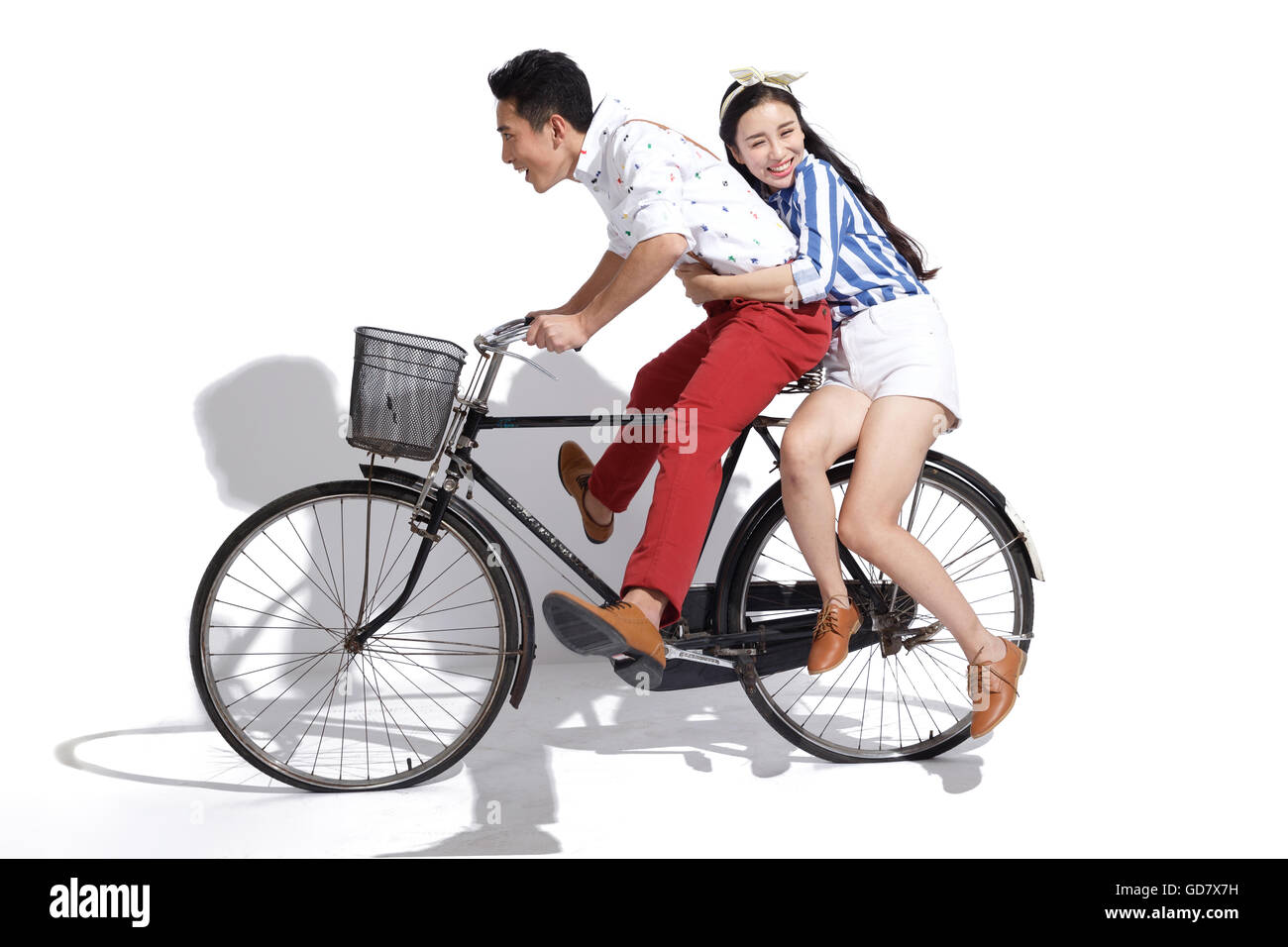Young couple riding a bicycle Stock Photo - Alamy