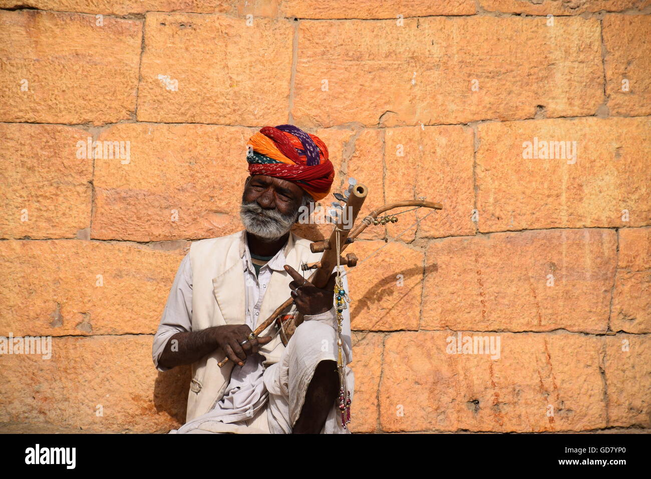 Old man playing traditional indian instrument inside Jaisalmer fort ...