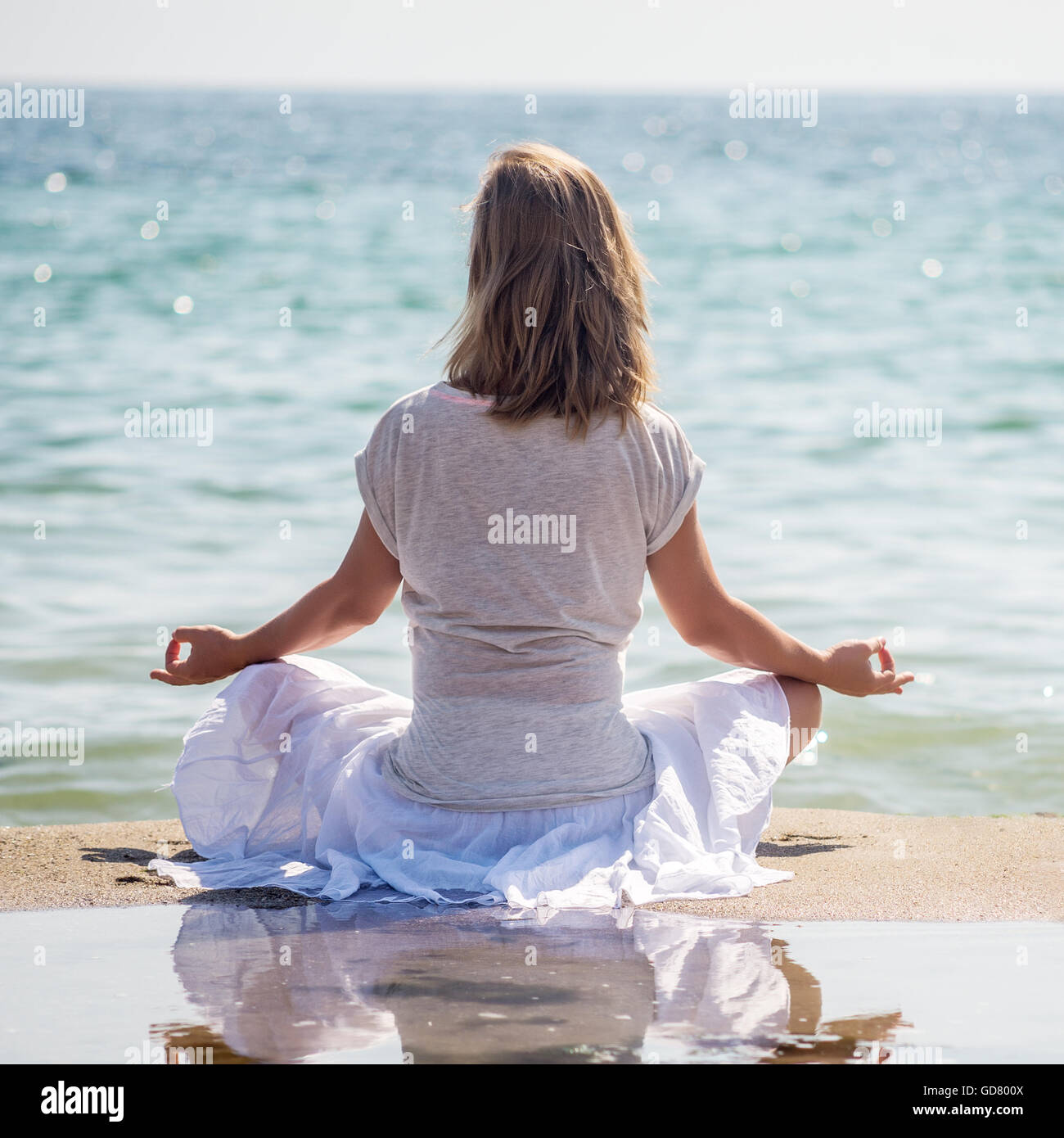 Woman meditating at the sea Stock Photo - Alamy