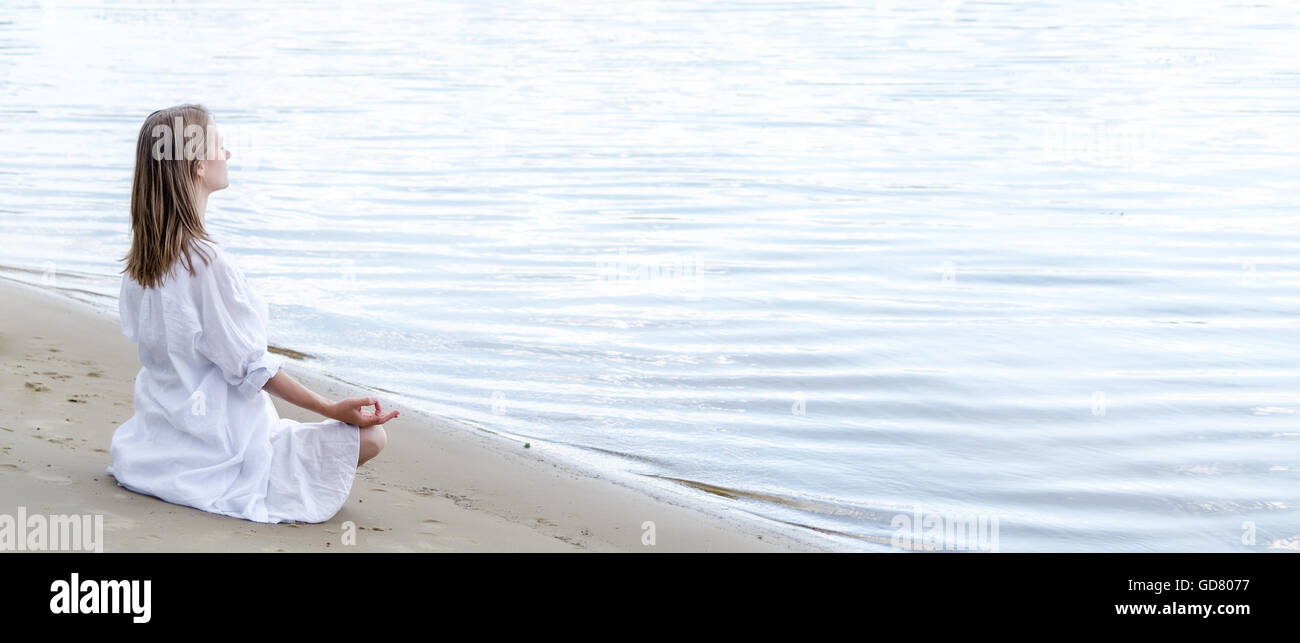 Woman meditating at the sea Stock Photo - Alamy