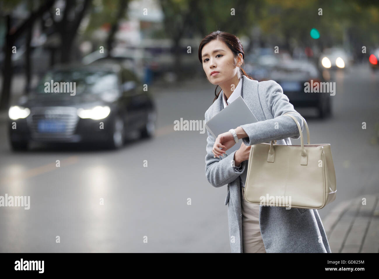 Young woman waiting for a taxi on the road Stock Photo - Alamy