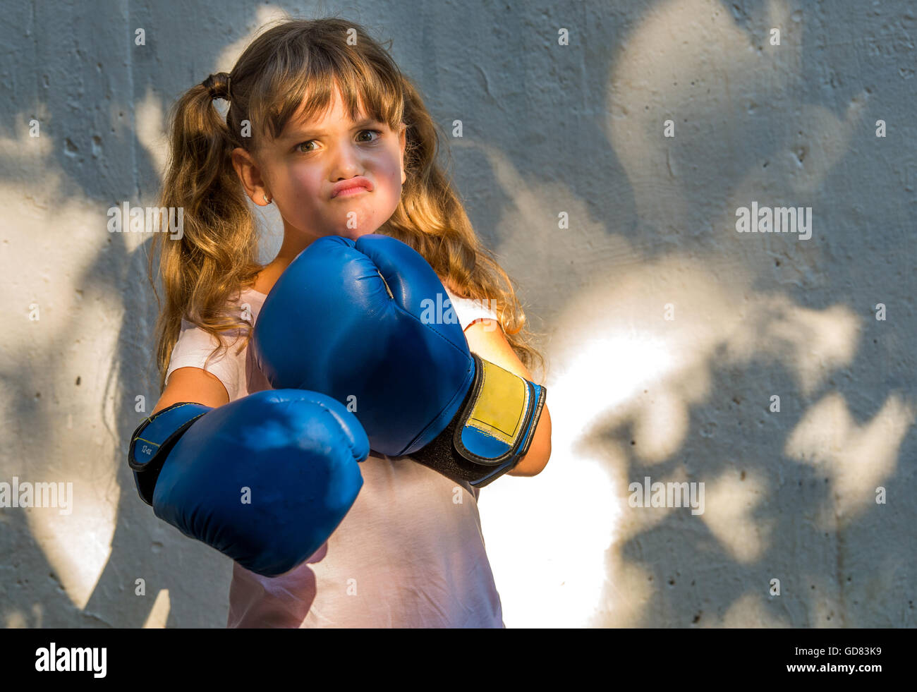 Little girl wearing blue boxing gloves Stock Photo - Alamy