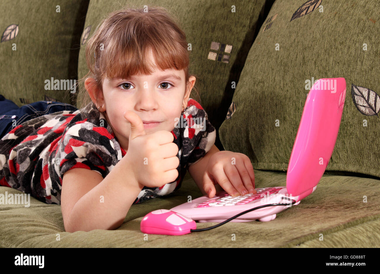 little girl with thumb up and laptop Stock Photo - Alamy