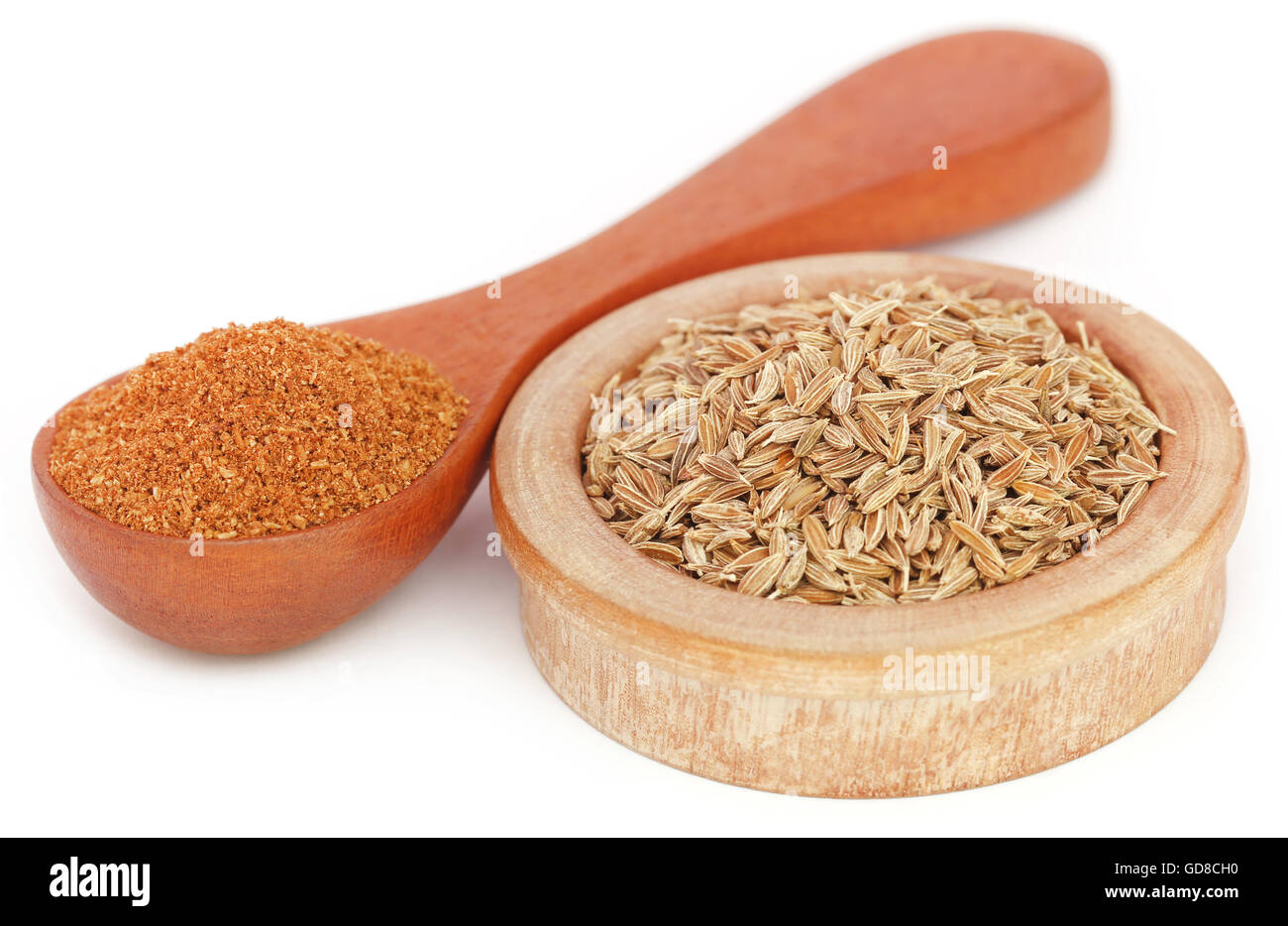 Crushed cumin with whole ones over white background Stock Photo - Alamy