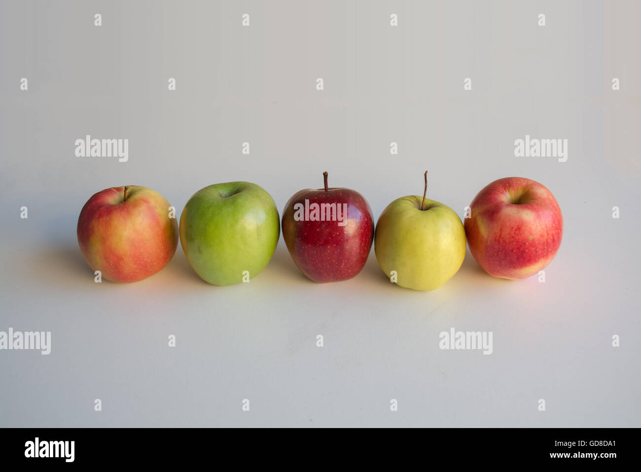 Five different apple varieties on light background Stock Photo - Alamy