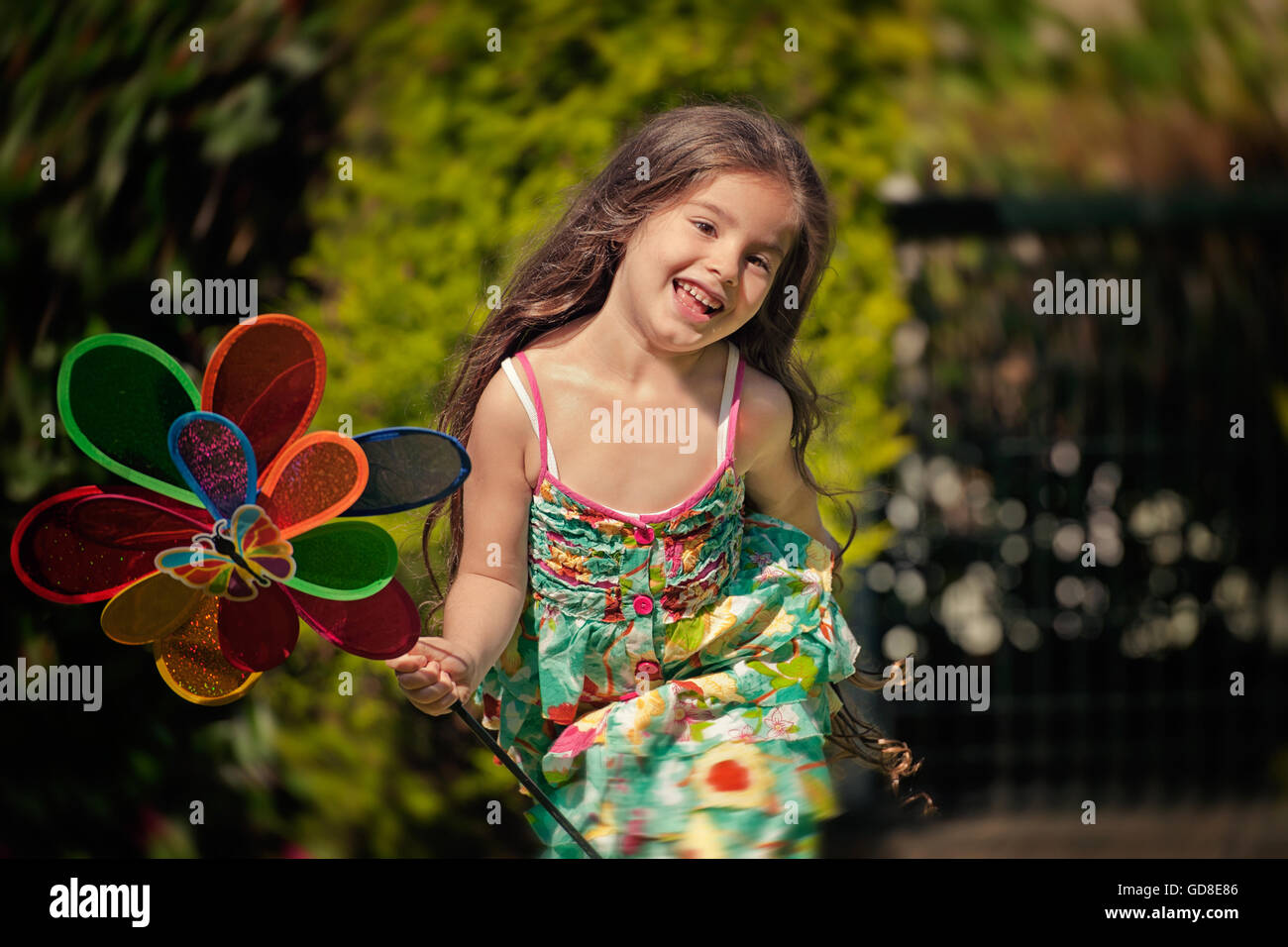 Girl playing with toy windmill Stock Photo - Alamy