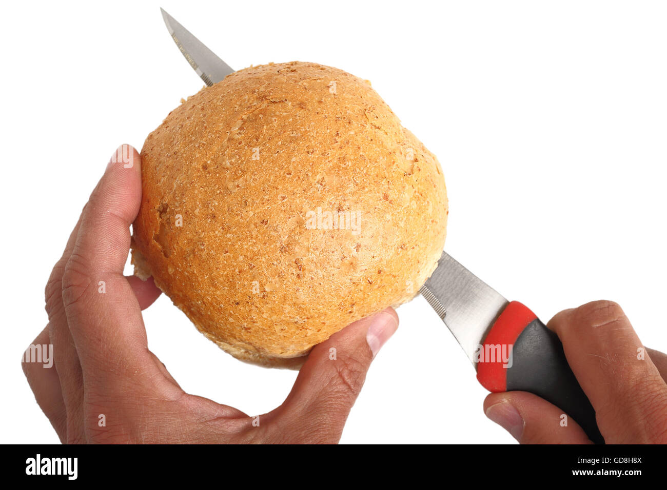 Cutting Graham bread roll in half. Isolated on white background ...