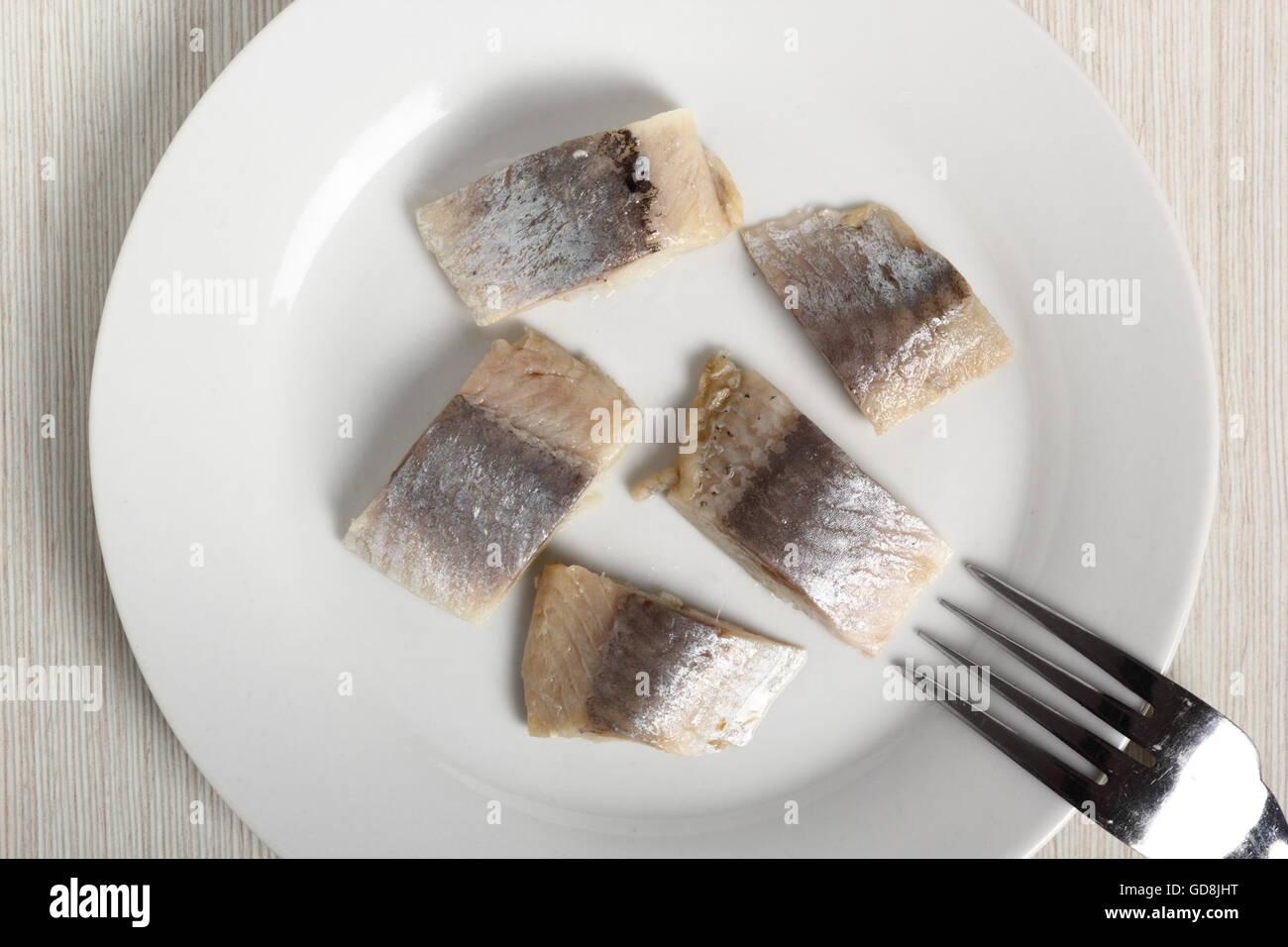 Pickled herring on plate. Salted, soused skinless slices of fish Clupea ...