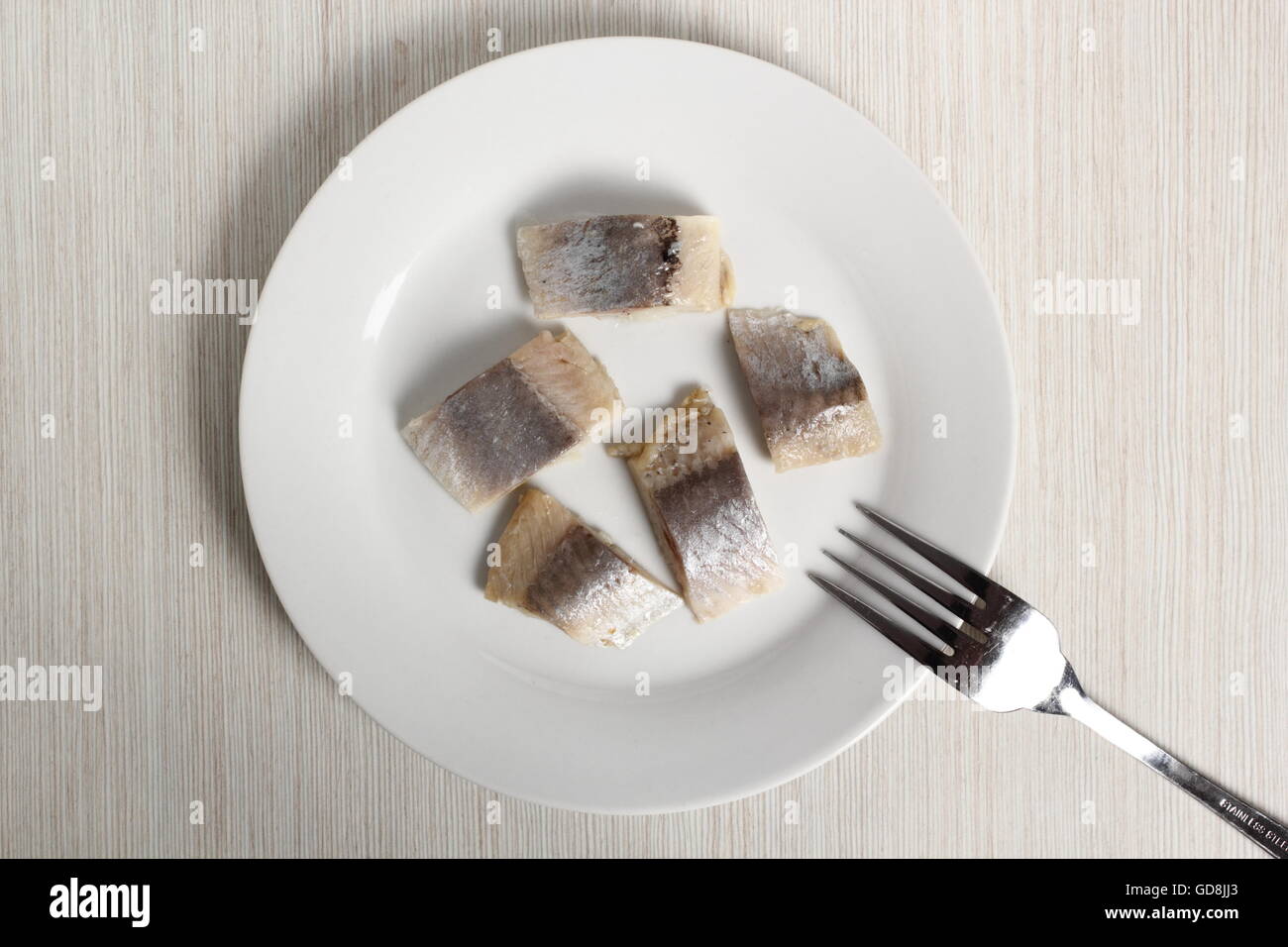 Pickled herring on plate. Salted, soused skinless slices of fish Clupea ...