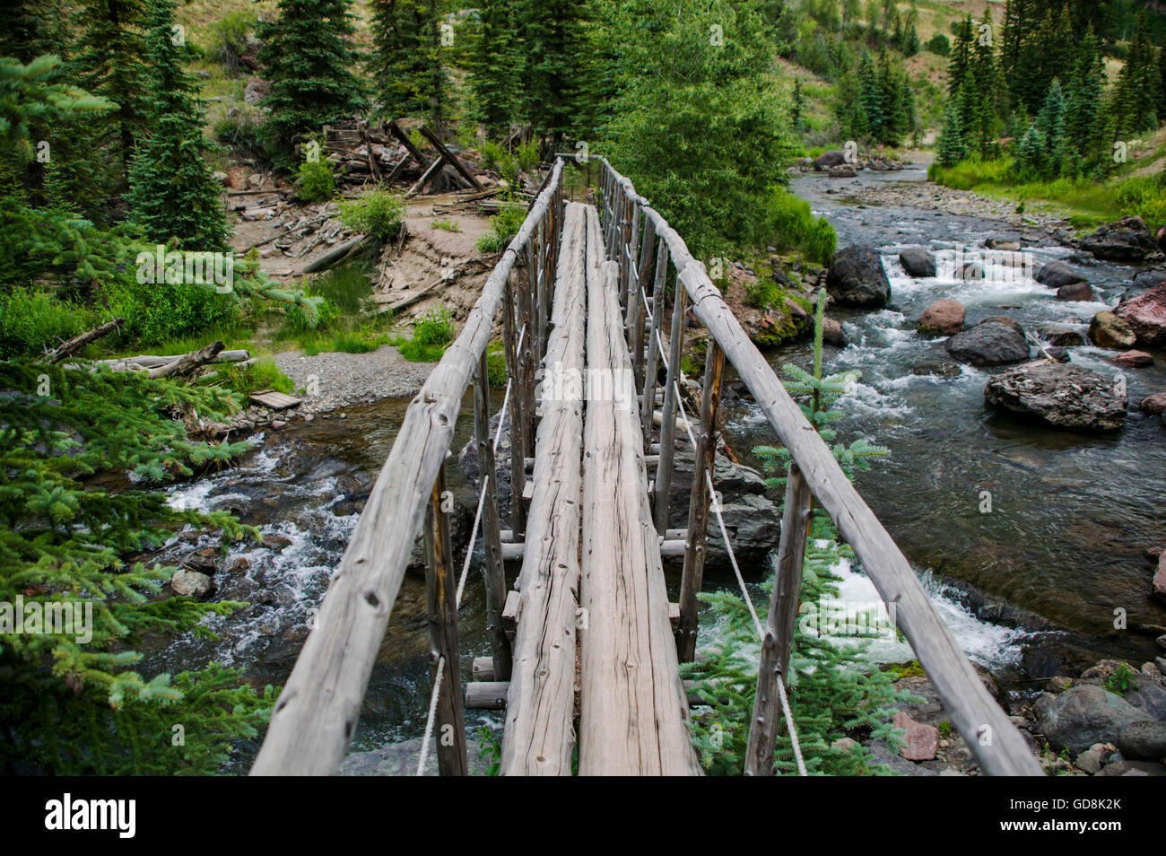 Handmade wooden pedestrian bridge over mountain stream near Telluride ...