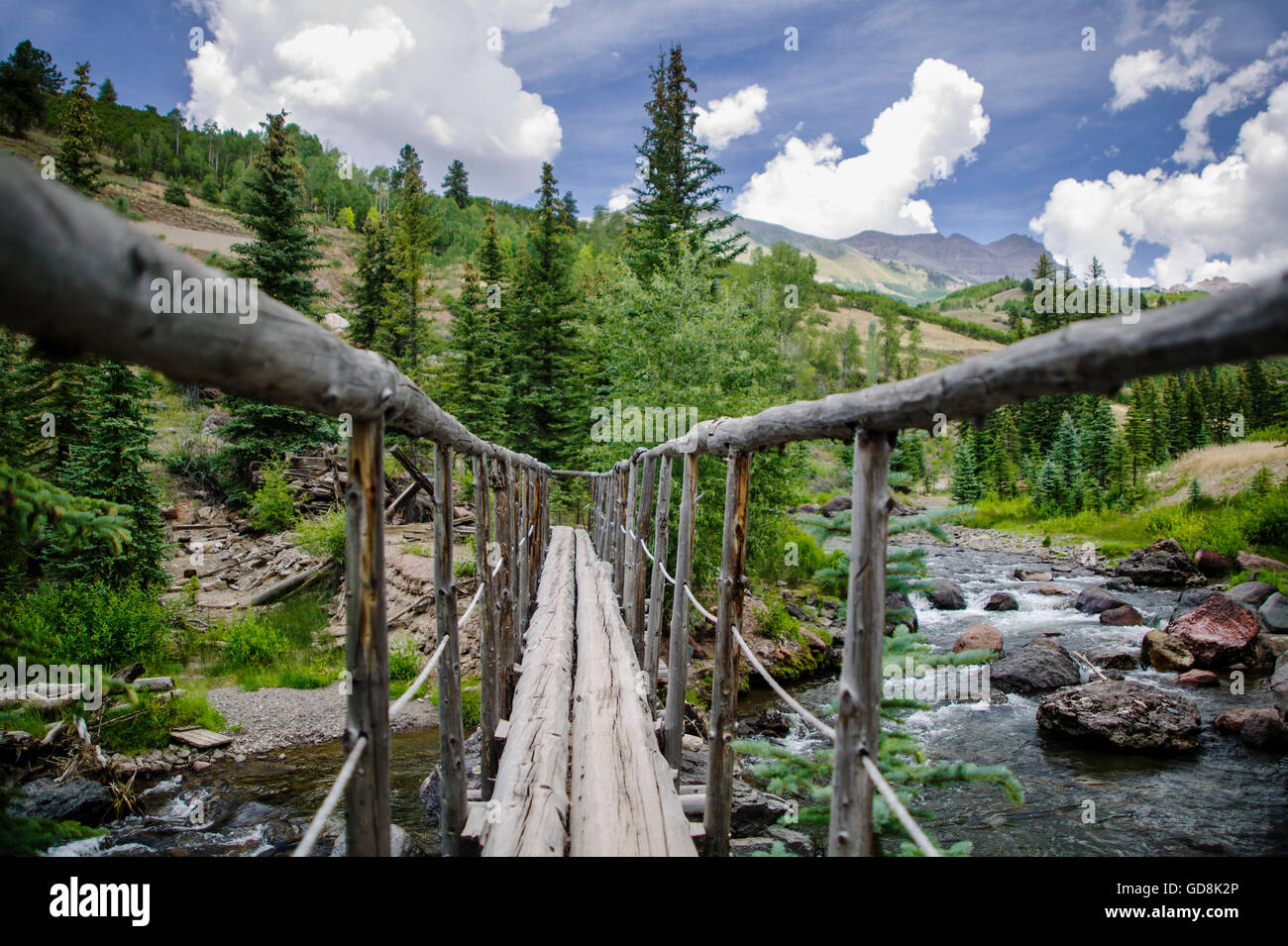 Handmade wooden pedestrian bridge over mountain stream near Telluride ...